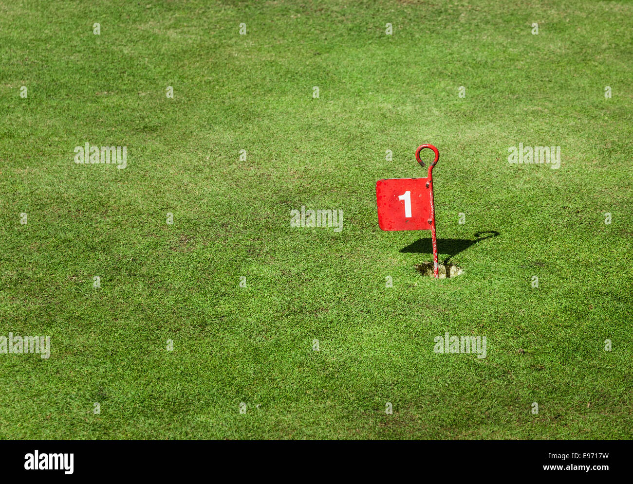 Old tin golf number one cup marker flag on a crazy golf green Stock ...