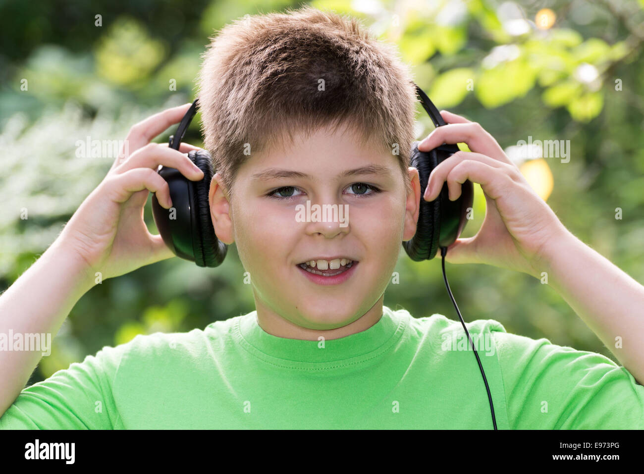 boy listening to music with headphones in park Stock Photo - Alamy