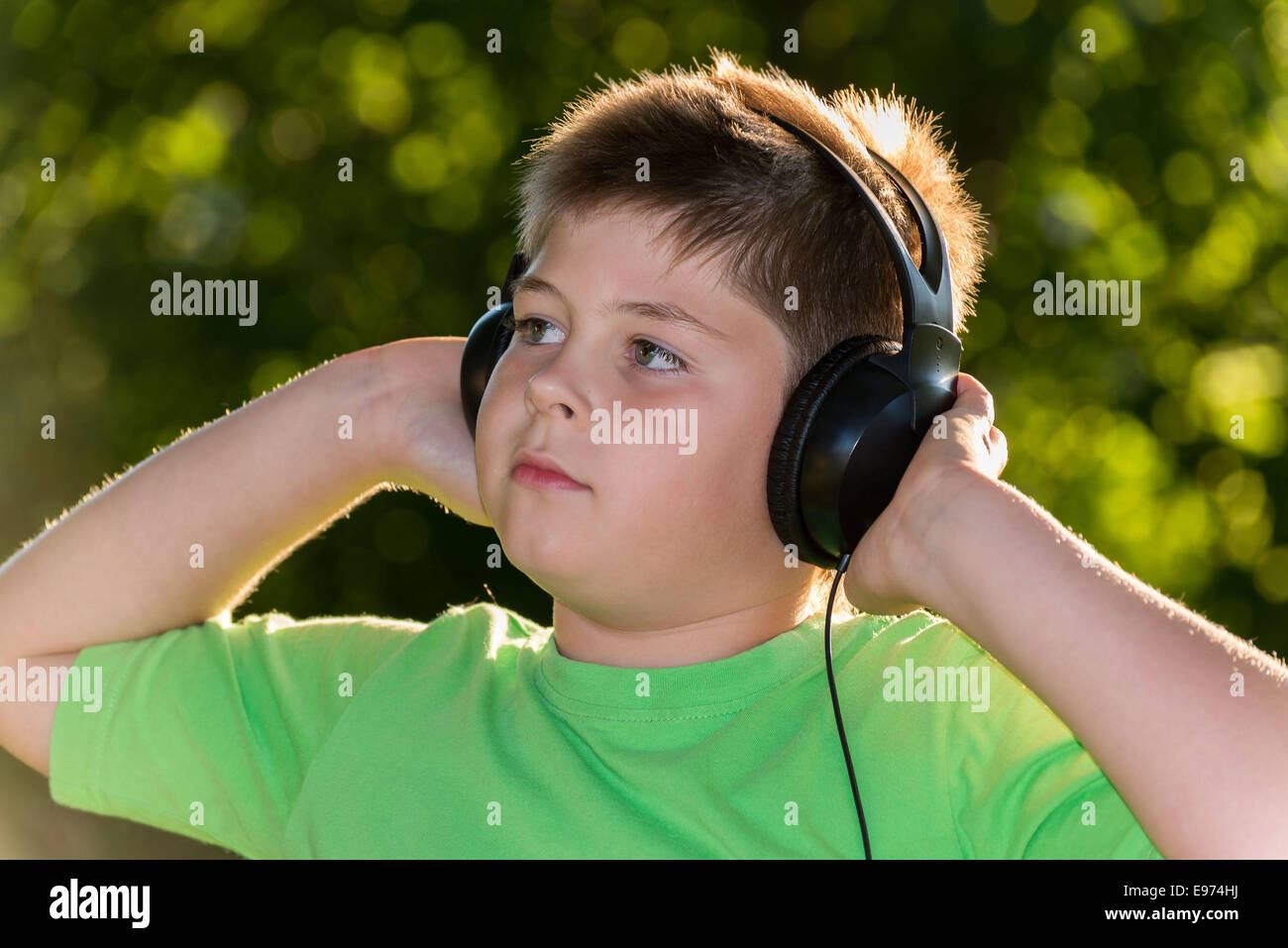 boy listening to music with headphones in park Stock Photo - Alamy