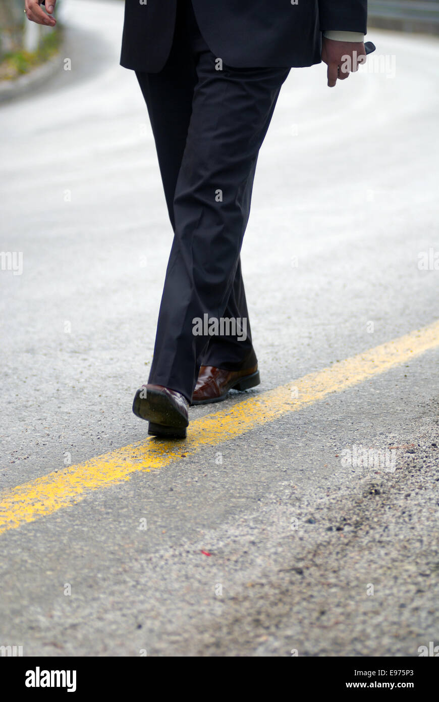 .businessman walking on yellow line Stock Photo - Alamy