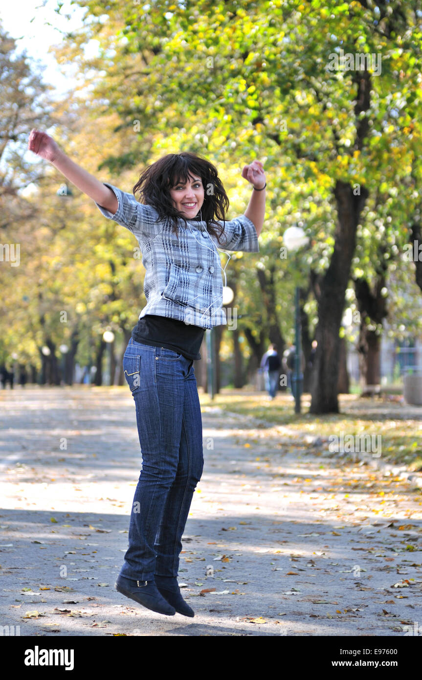 brunette Cute young woman dancing outdoors Stock Photo - Alamy