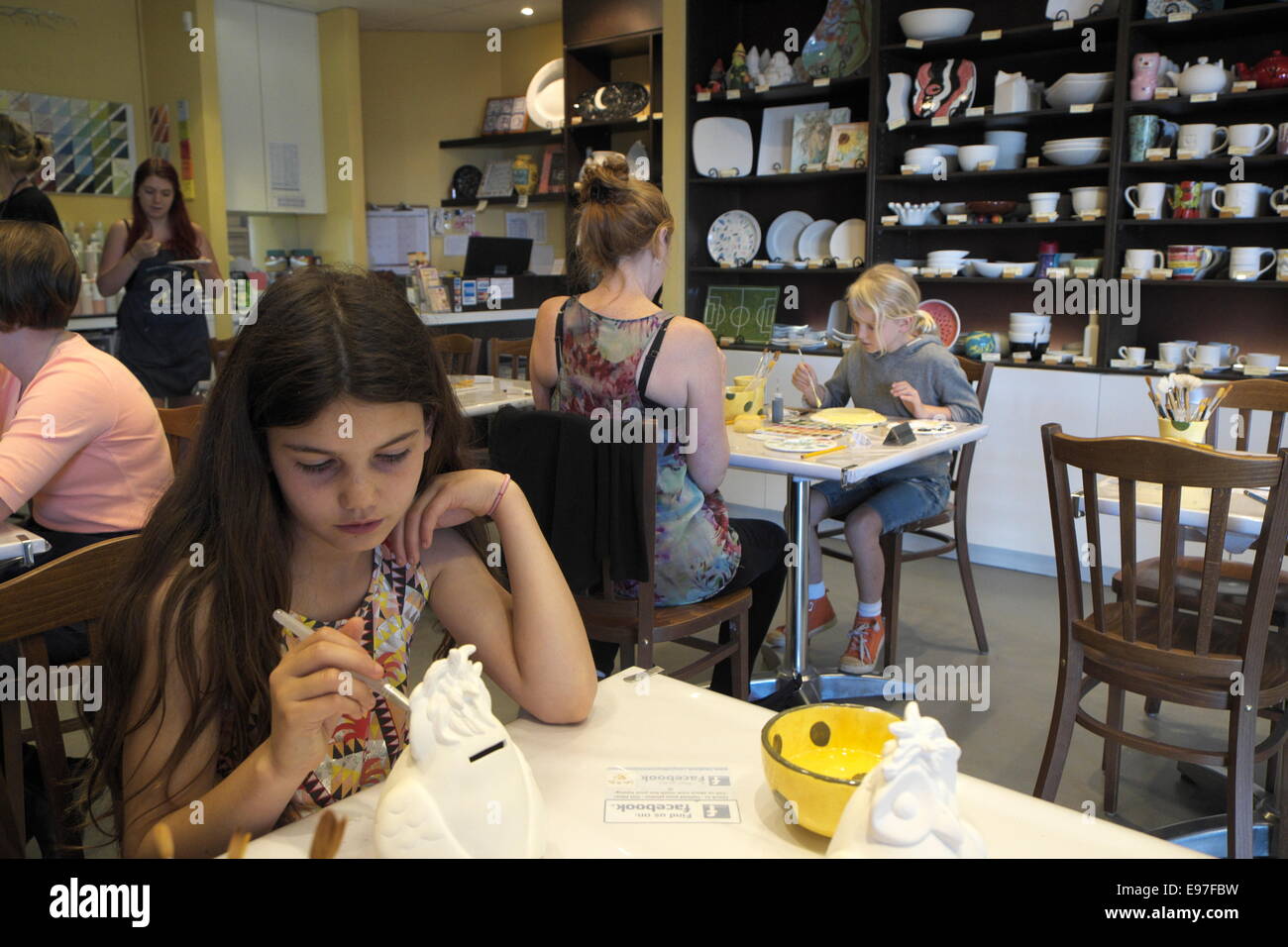 children in an art shop undertaking paint a pot school holiday activity ...