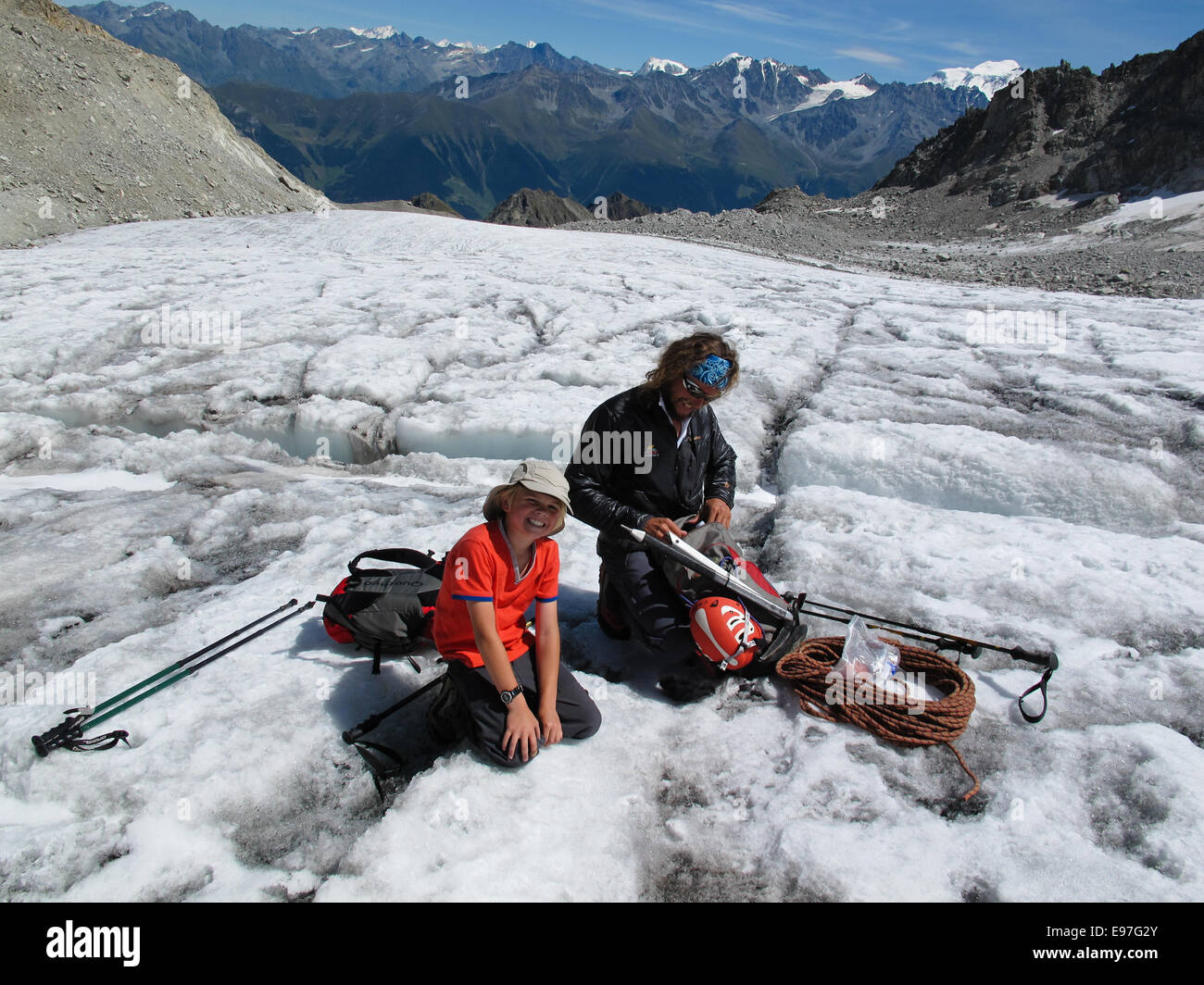 Mountain guide and his young boy client adjusting equipment on the ...