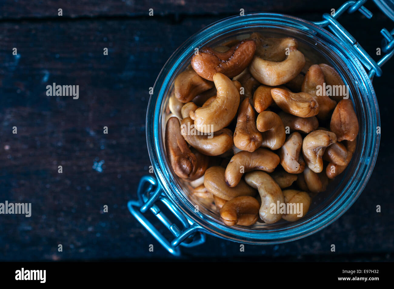 Fried cashew nuts in glass jar on wooden background with blank space on ...