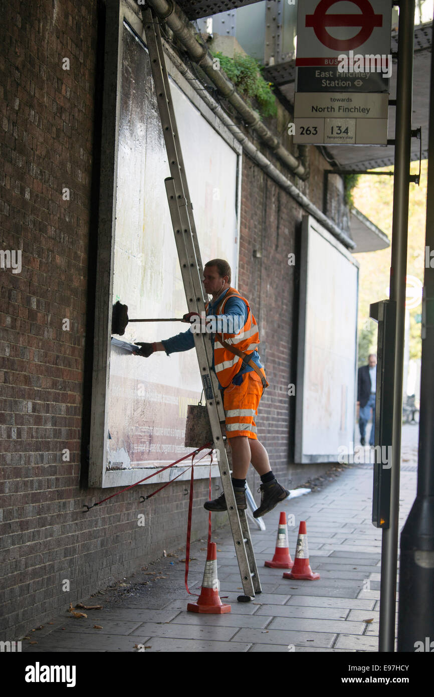 Bill stickers sticking poster advert billboard pasting Stock Photo - Alamy