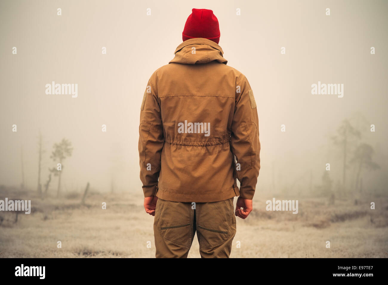Young Man standing alone outdoor with foggy scandinavian nature on ...