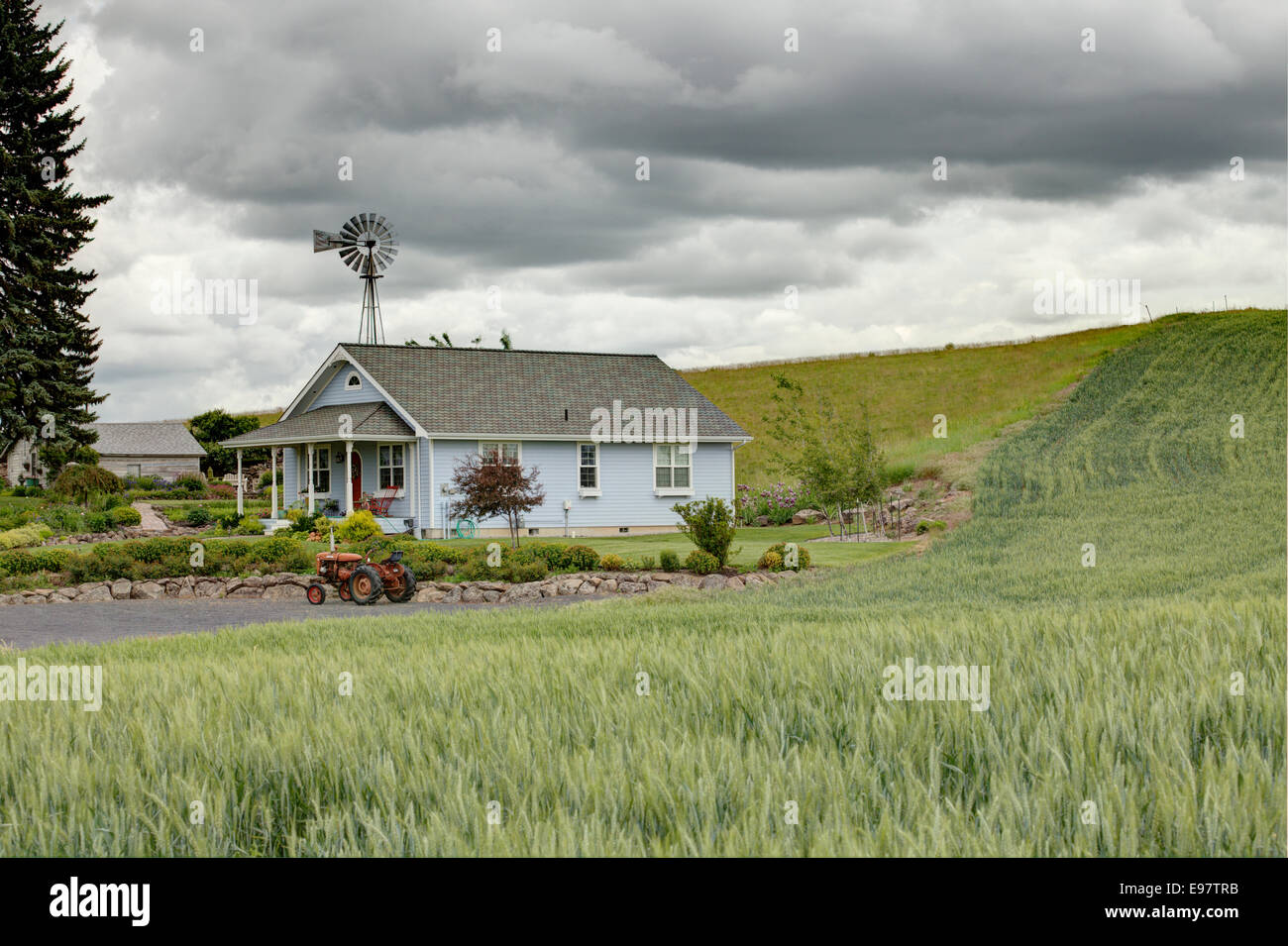A farmhouse and windmill under a stormy sky Stock Photo - Alamy