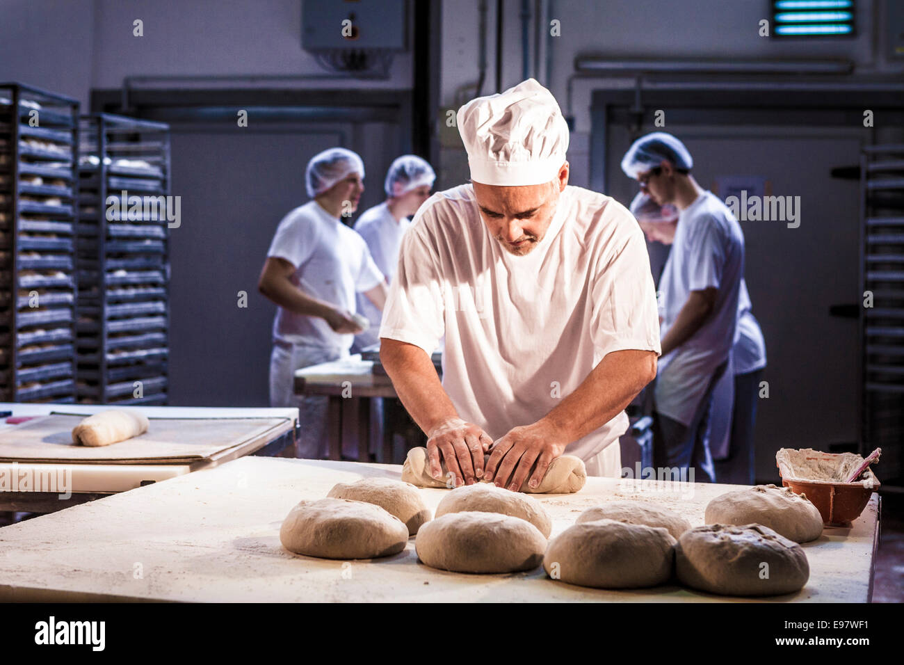 Baker making bread, kneading dough Stock Photo - Alamy