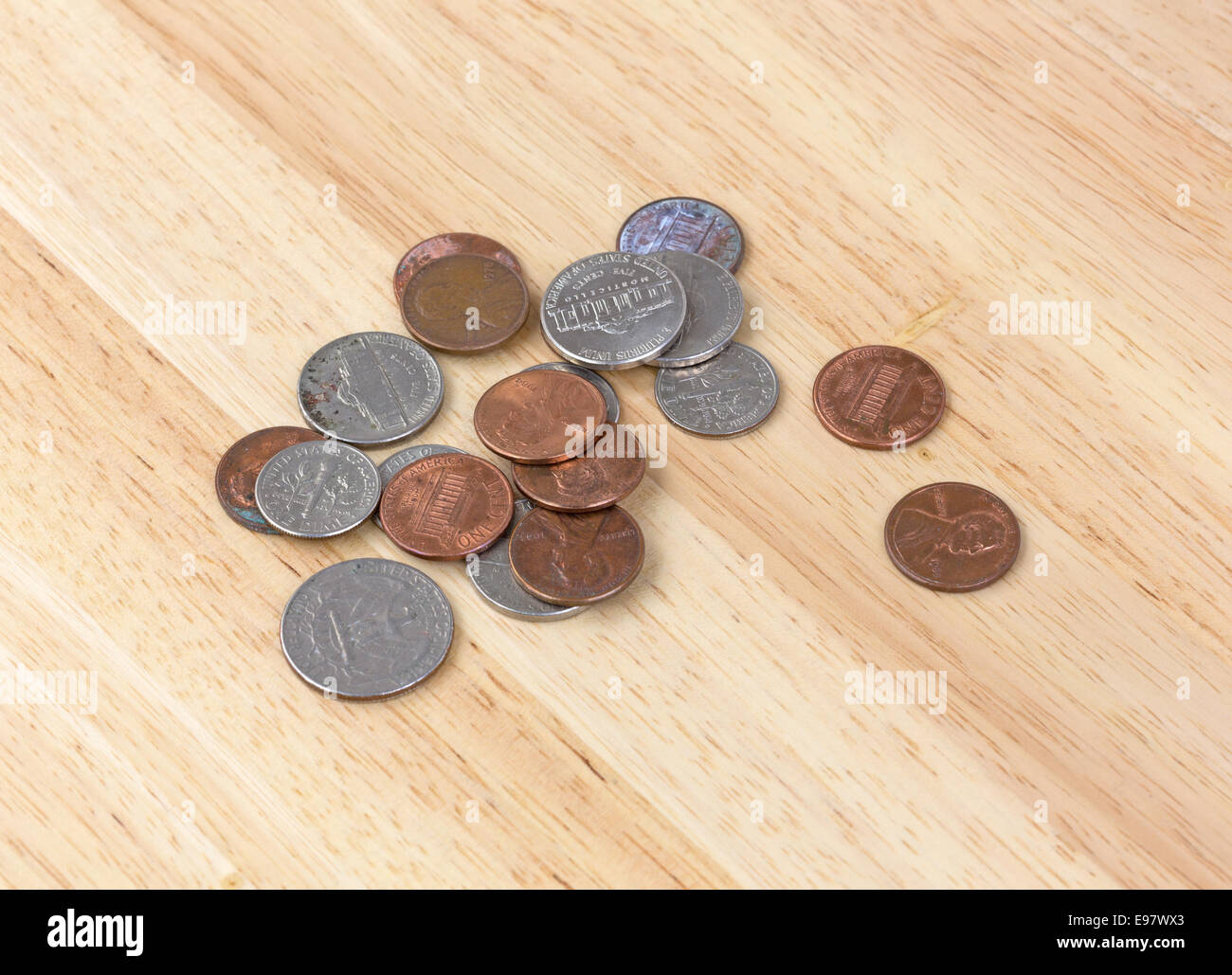 Several coins lying on a wood tabletop Stock Photo - Alamy