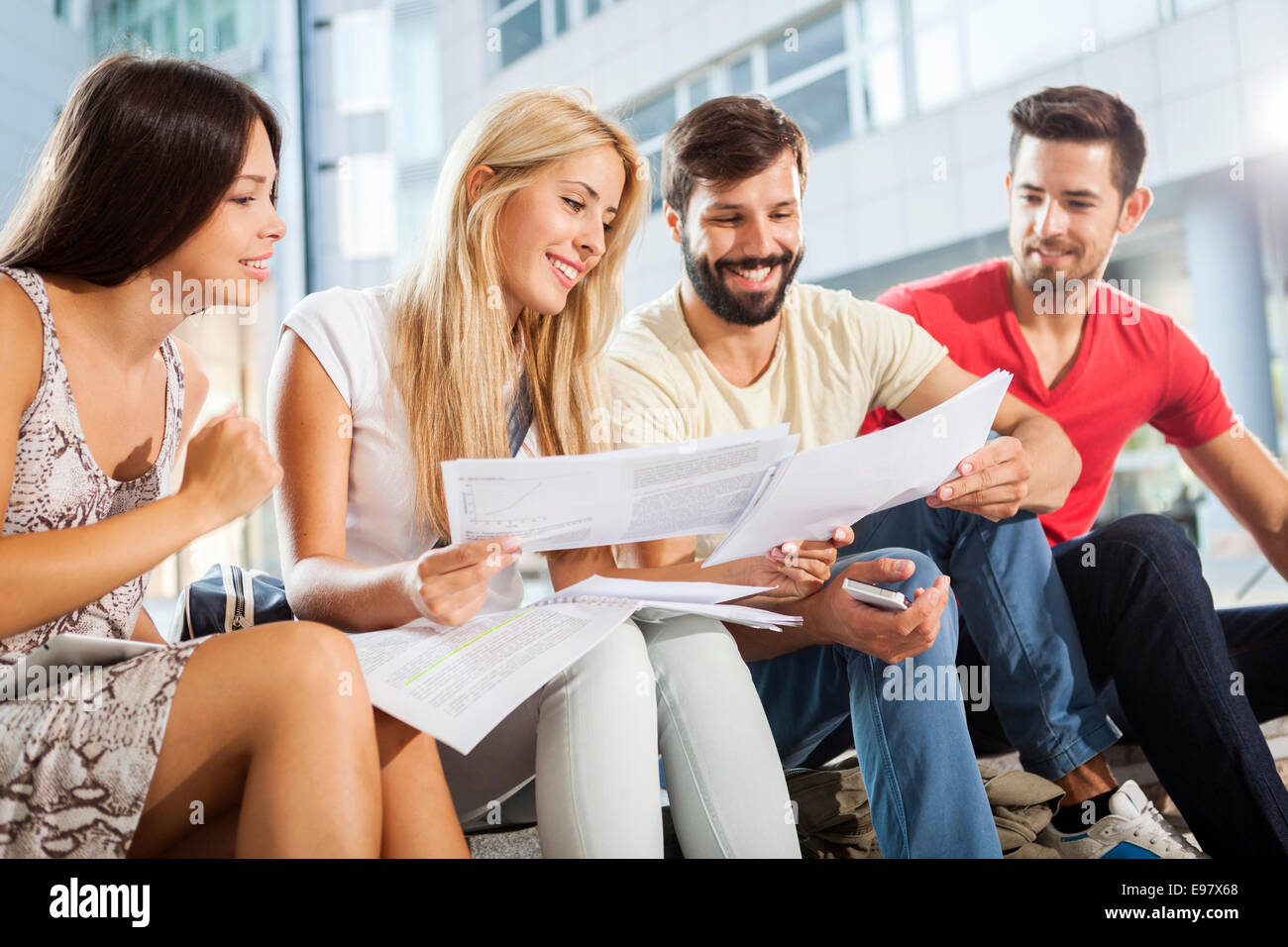 Group of students reading documents Stock Photo - Alamy