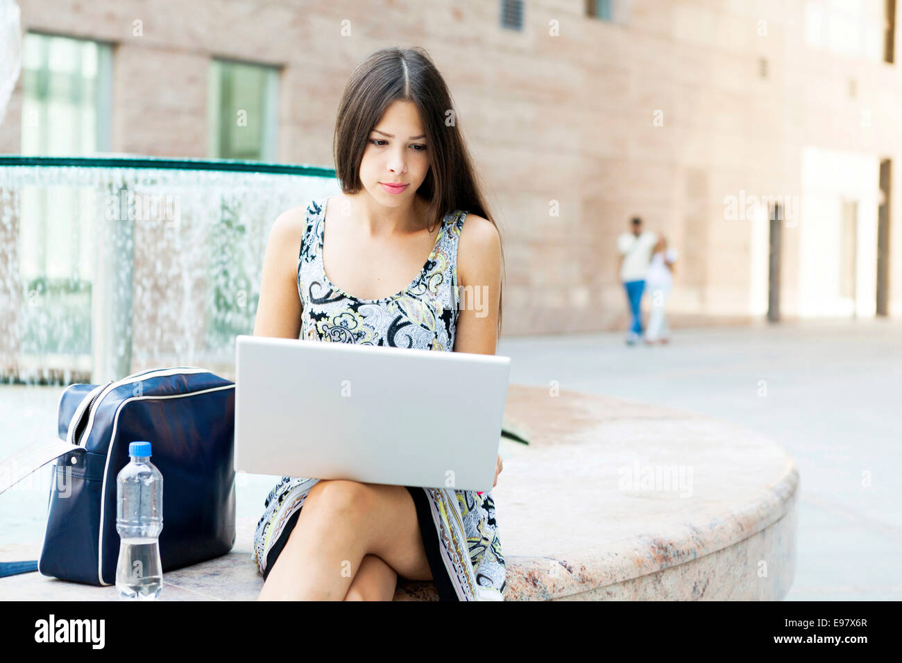 Female student using laptop on campus grounds Stock Photo - Alamy