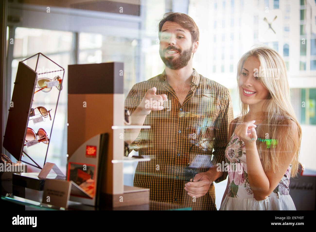 Young couple looking through shop window Stock Photo - Alamy