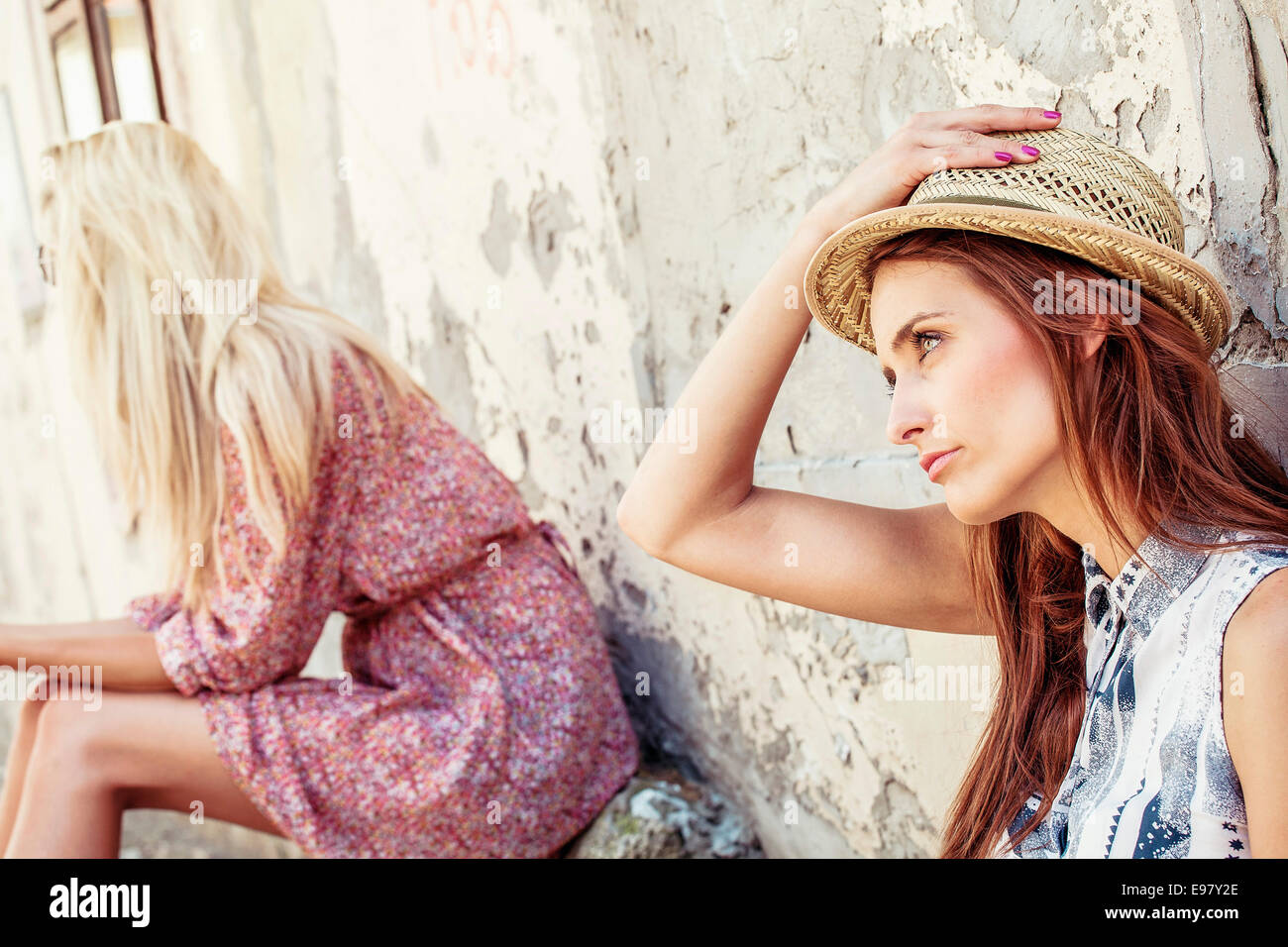 Two bored women with luggage waiting outdoors Stock Photo - Alamy