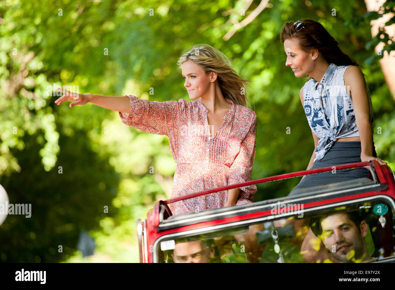 Young woman in convertible car pointing with hand Stock Photo - Alamy