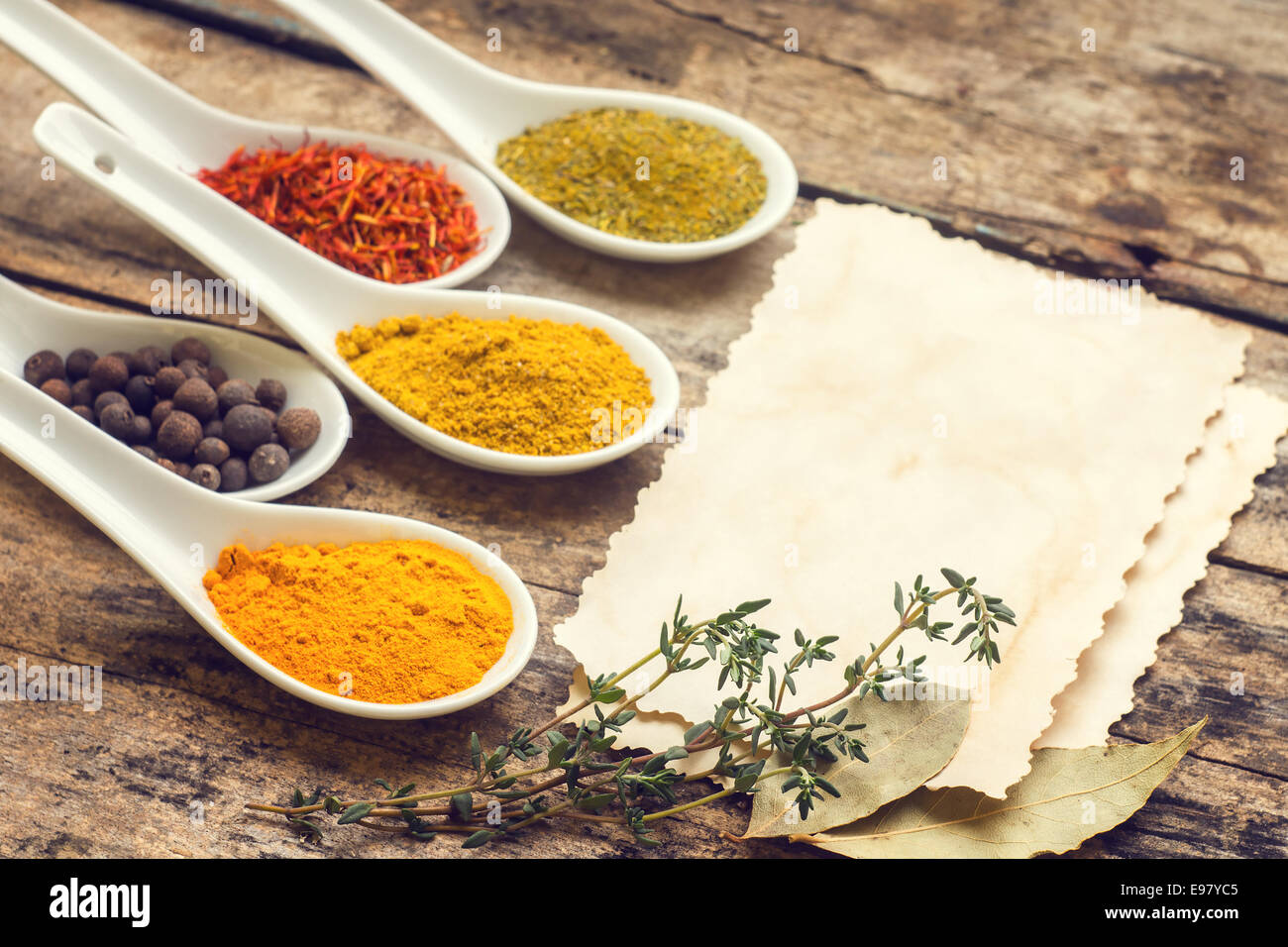 Various Spices with bunch of thyme and vintage paper sheets on wooden ...