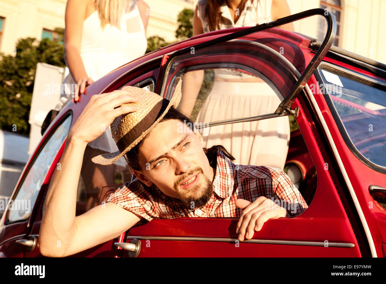 Young man in vintage car looking through window Stock Photo - Alamy