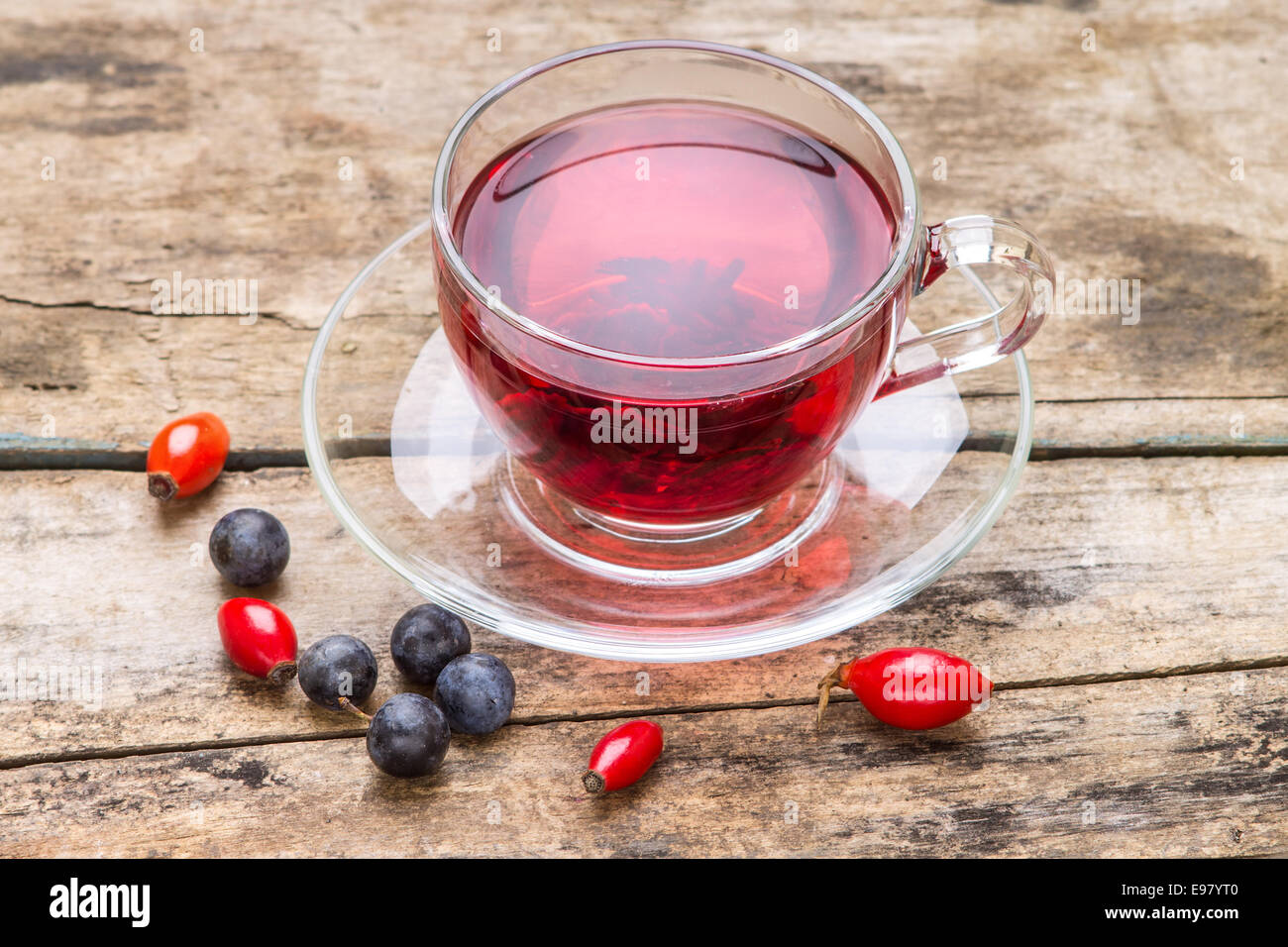 Glass Cup of red karkade tea with wild berries on wood background Stock ...