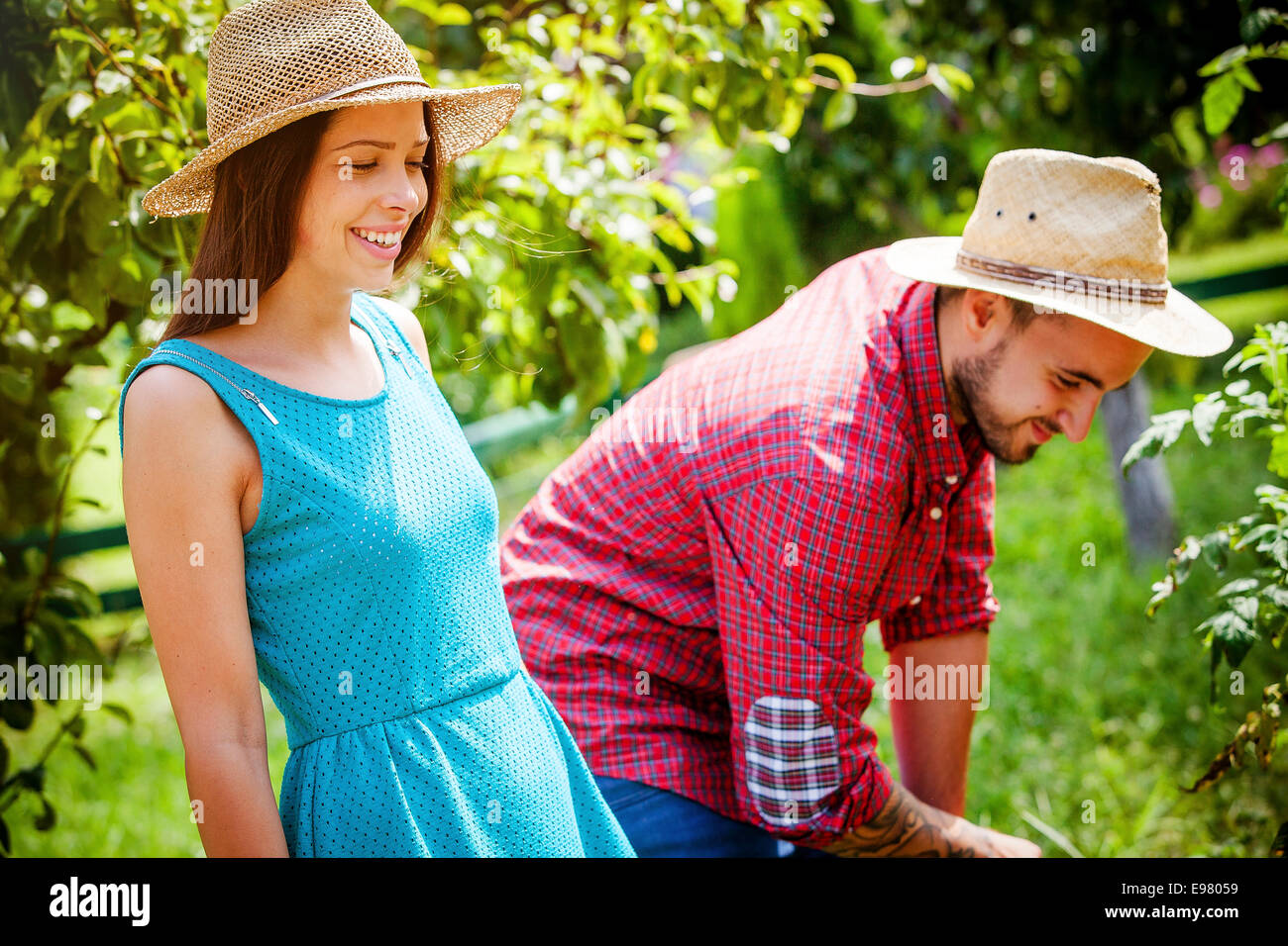 Young couple taking a break in vegetable garden Stock Photo - Alamy