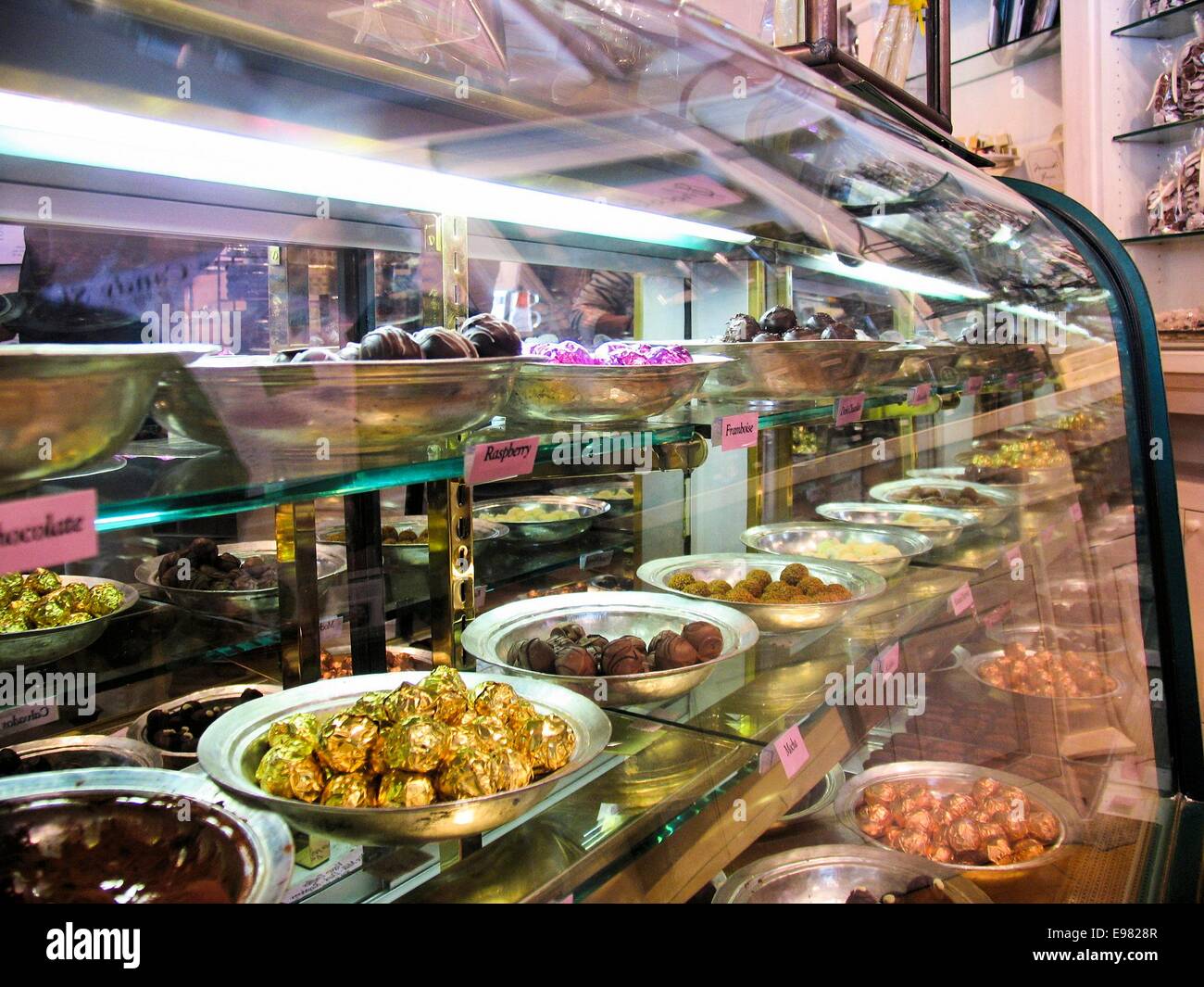 View of a glass Candy store counter with varoius colored chocolates ...