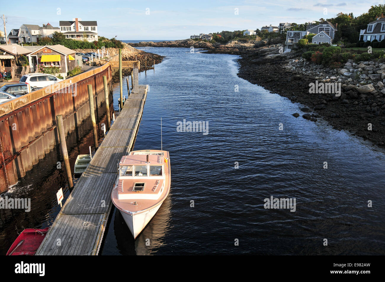 A boat docked to pier in inlet to Perkins Cove harbor in Maine. boat is ...