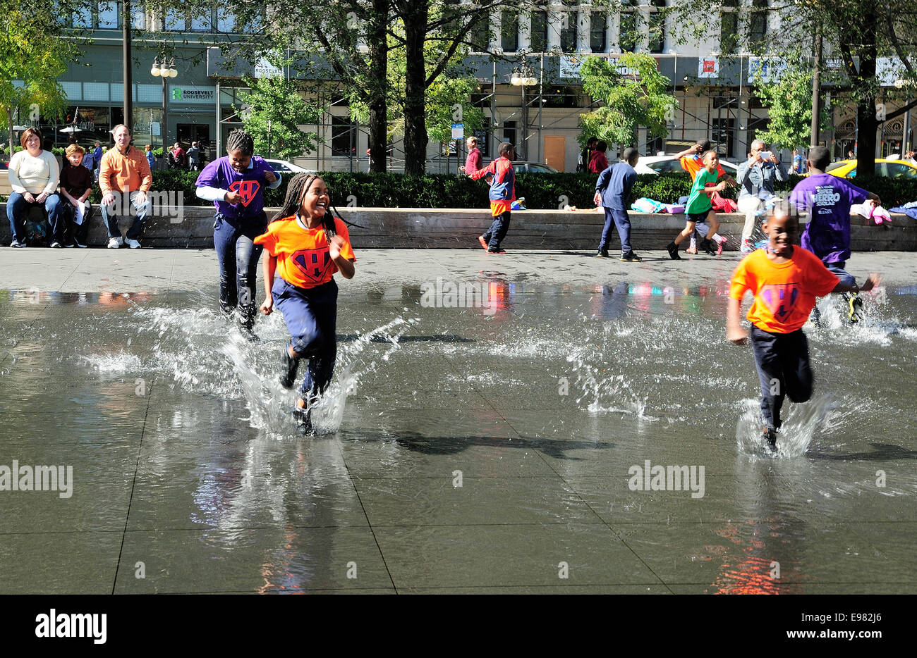 Chicago school kids on field trip playing in Crown Fountains reflecting ...