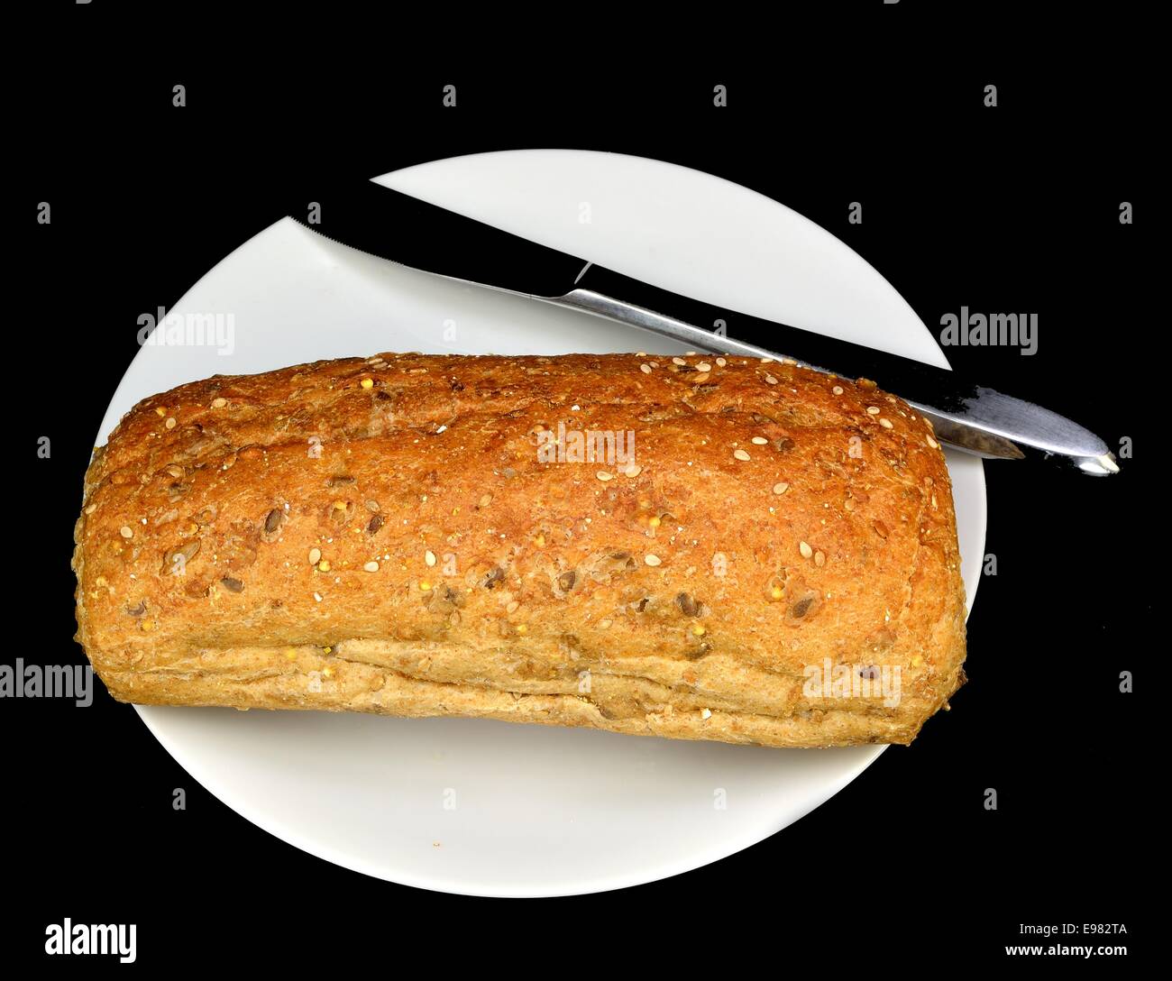 Large multigrain roll on a black background Stock Photo - Alamy