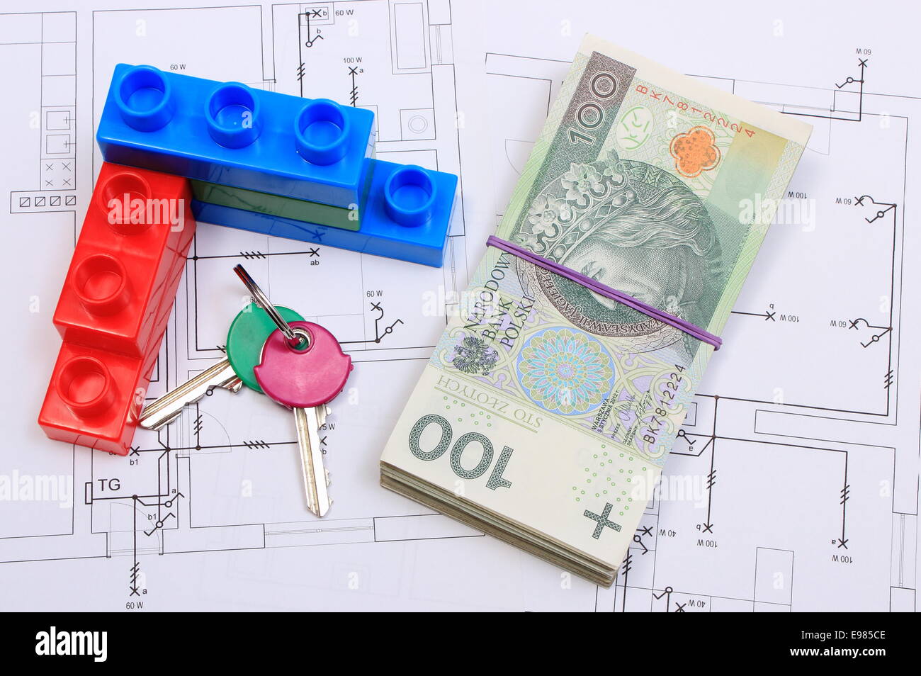 Heap of banknotes, home keys and wall of plastic colorful building ...