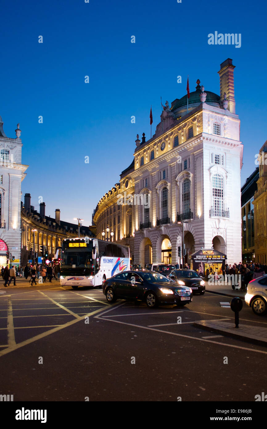 London Piccadilly Circus at dusk with deep blue sky and white bus and ...