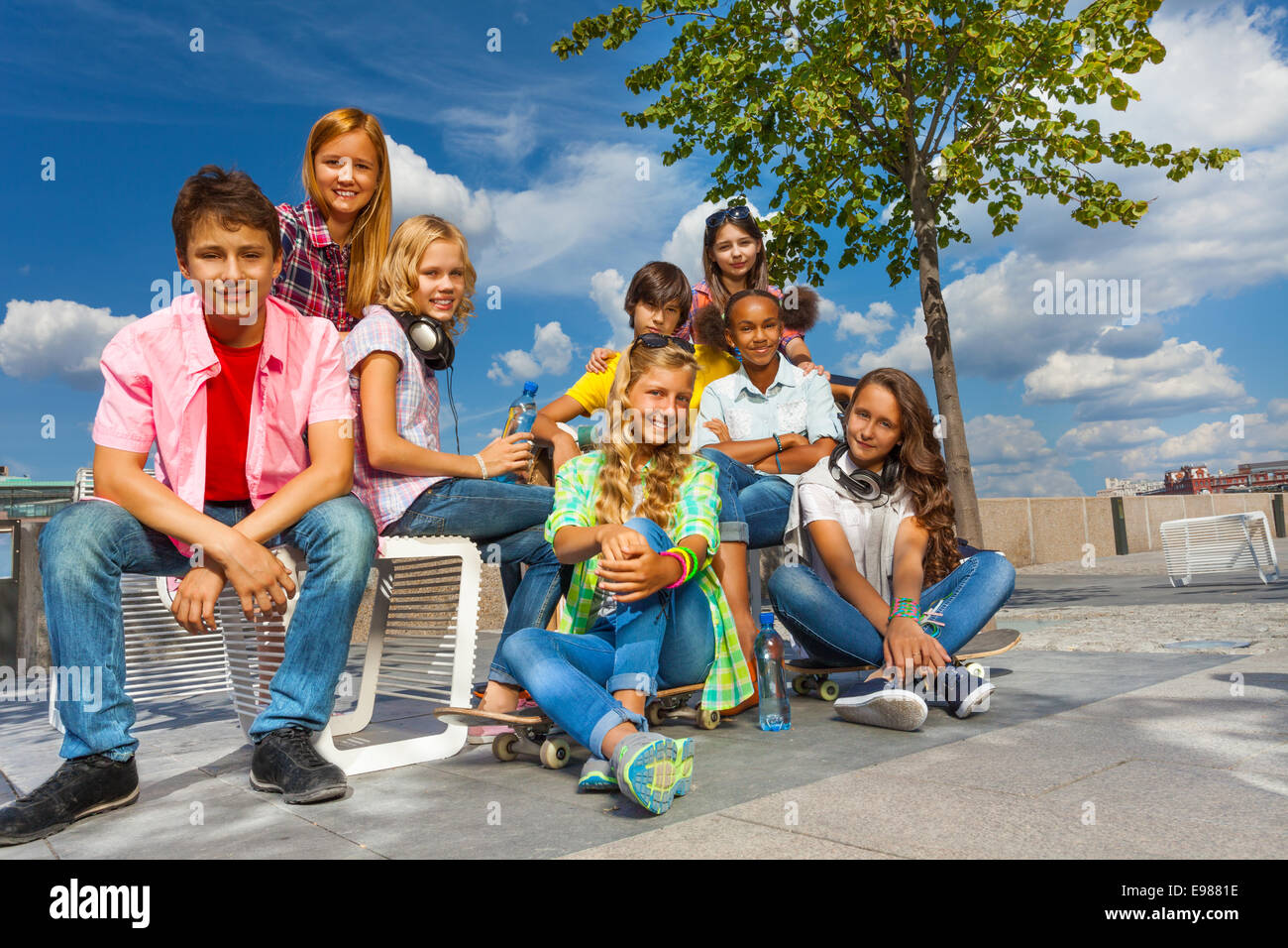 Happy friends sit on chairs of the embankment Stock Photo - Alamy