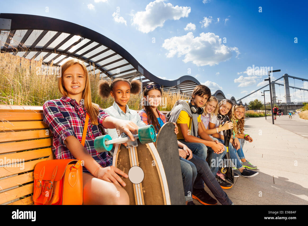 Group of children sitting on wooden bench together Stock Photo - Alamy