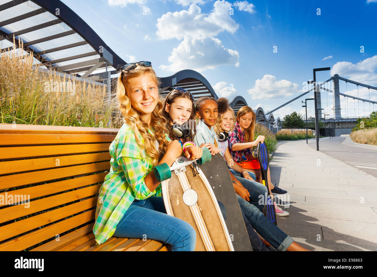 Kids sit on bench in summer with skateboards Stock Photo - Alamy