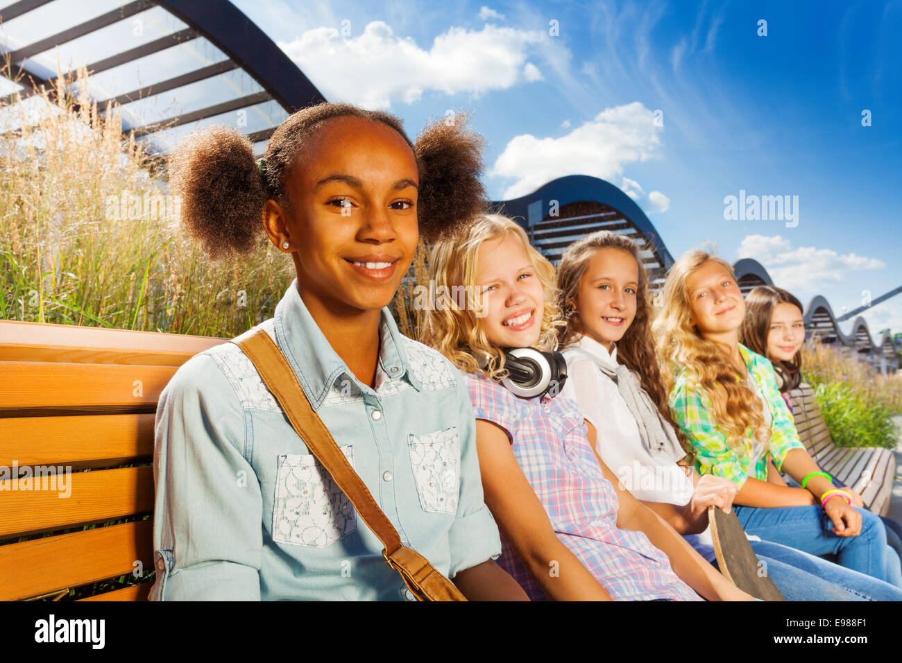 Girls smiling and sitting on the bench in summer Stock Photo - Alamy