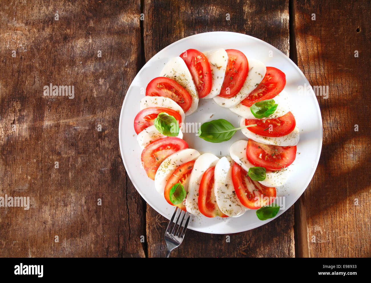 Overhead view of a decorative sliced tomato and cheese salad arranged ...