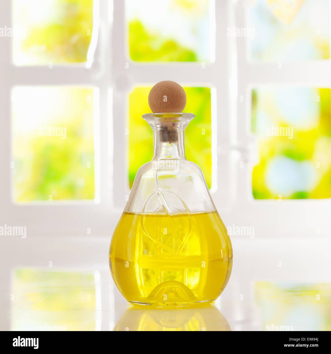 Glowing golden olive oil in a stoppered glass container for dispensing ...