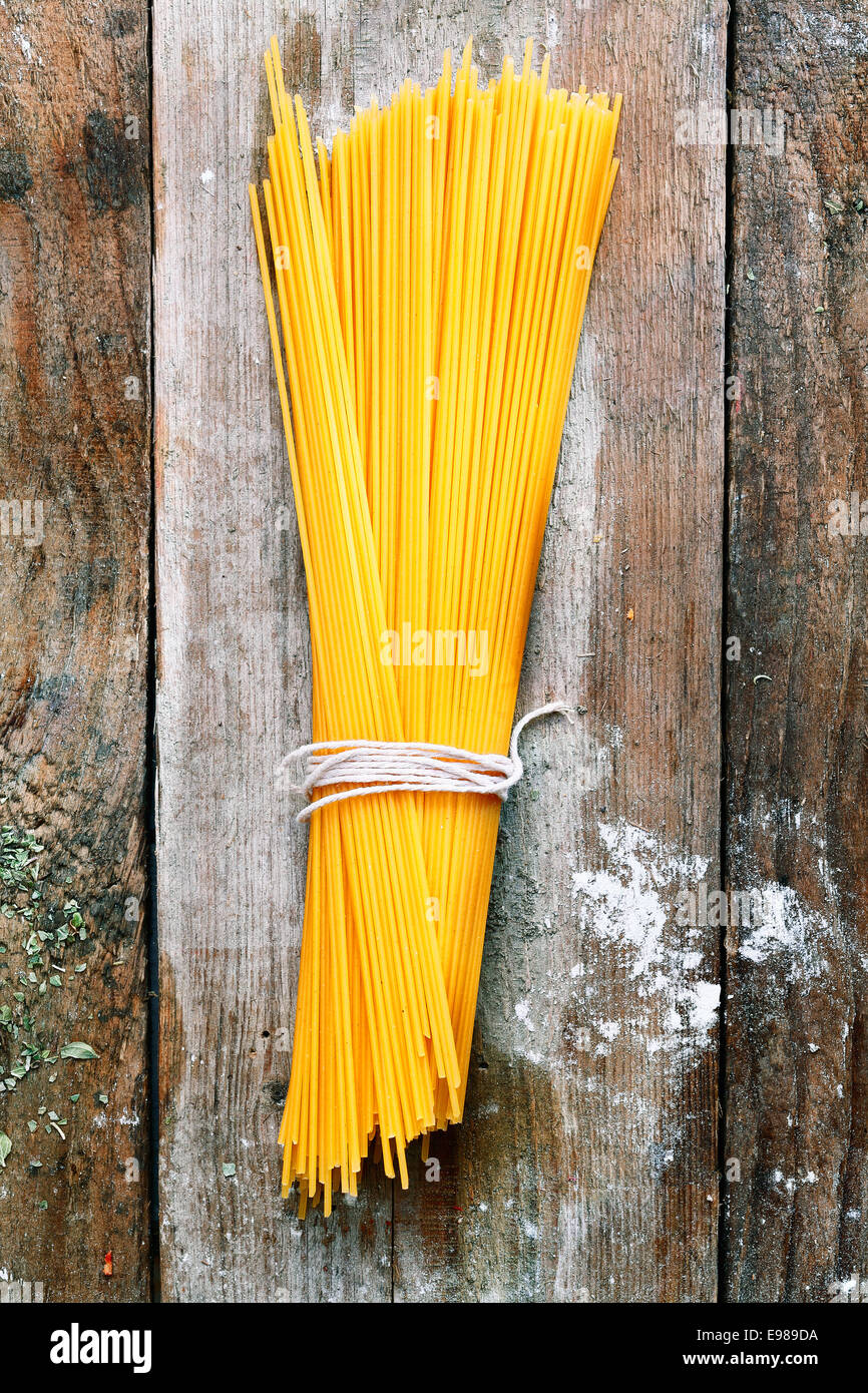 Bundle of Italian spahgetti pasta tied with string lying on old ...