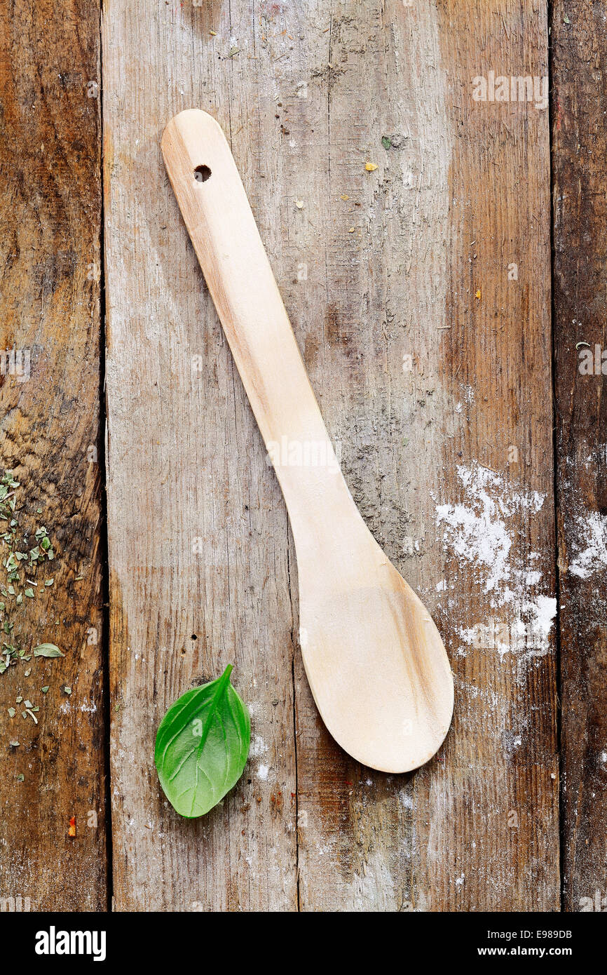 Wooden kitchen spoon lying on an old textured wooden surface with ...