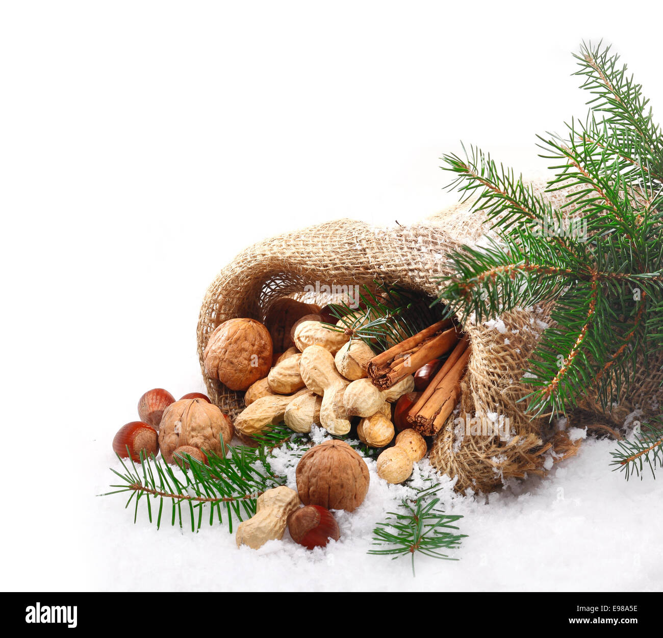 Fresh whole nuts and spices spilling out of a rustic hessian sack onto ...