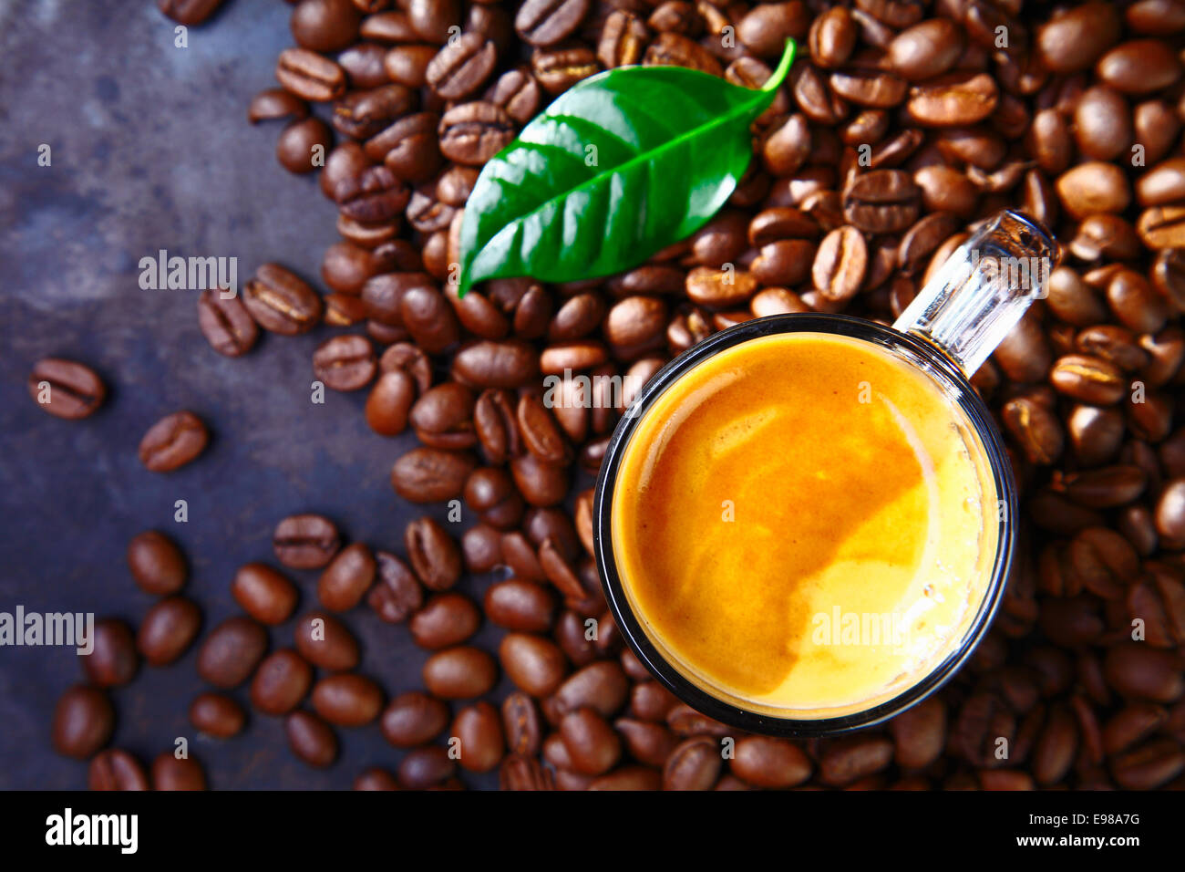 Delicious cup of coffee with beans and green coffe plant leaf Stock ...