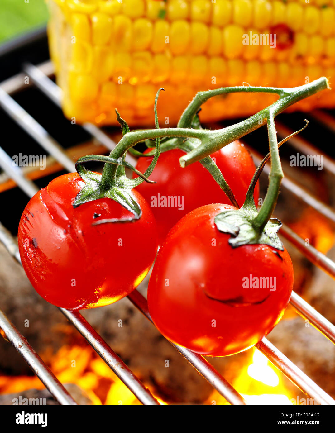Three ripe red cherry tomatoes still attached to the vine balanced on a ...