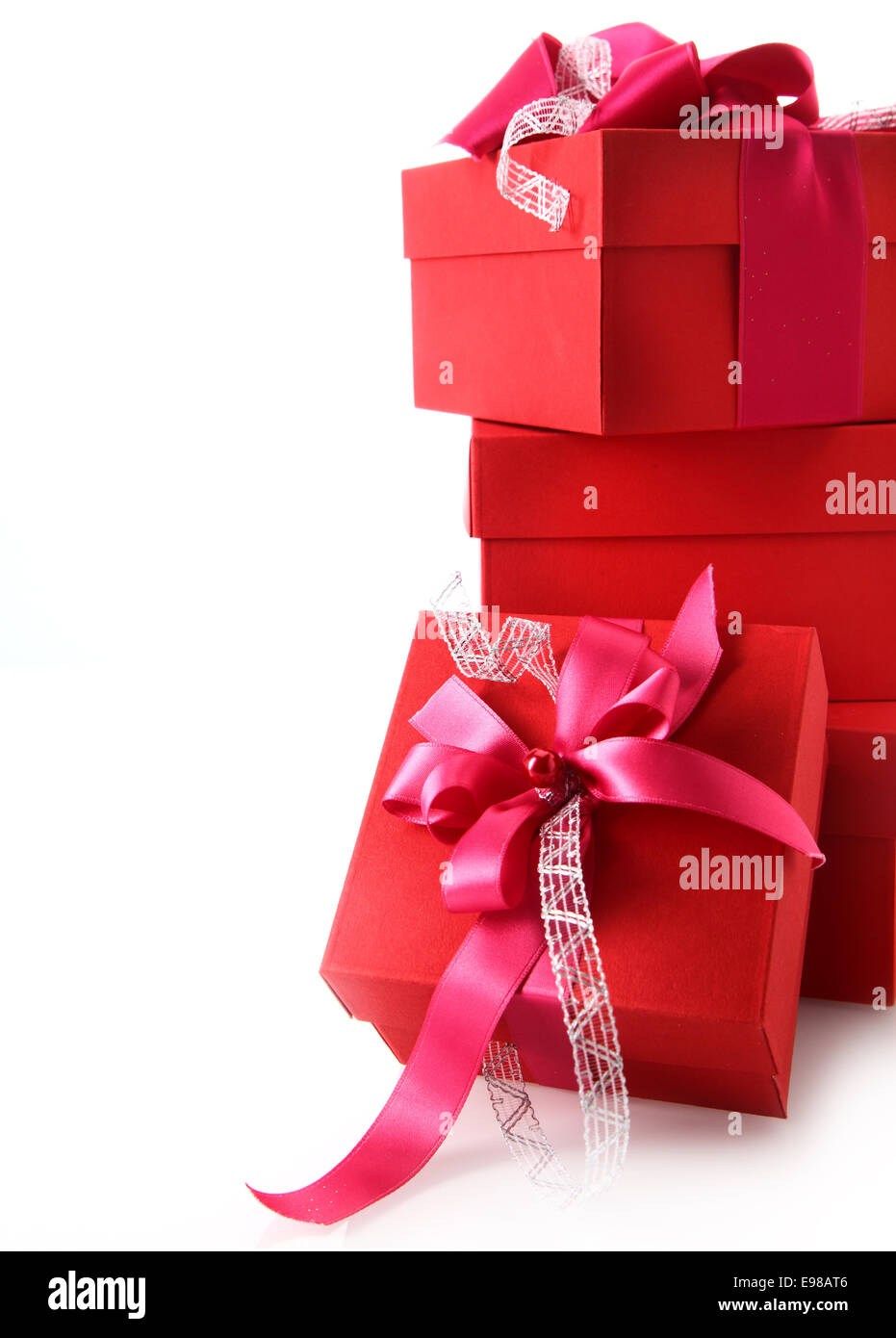 Stack of colourful red Christmas gifts tied with pretty red ribbons and ...