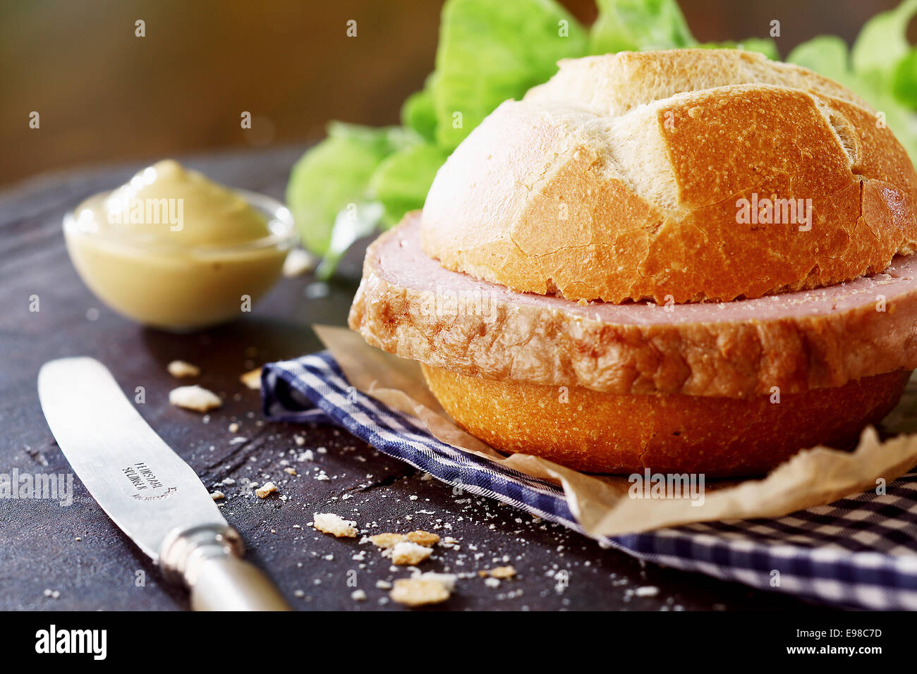 Preparing a traditional German meat loaf roll in a rustic kitchen with ...