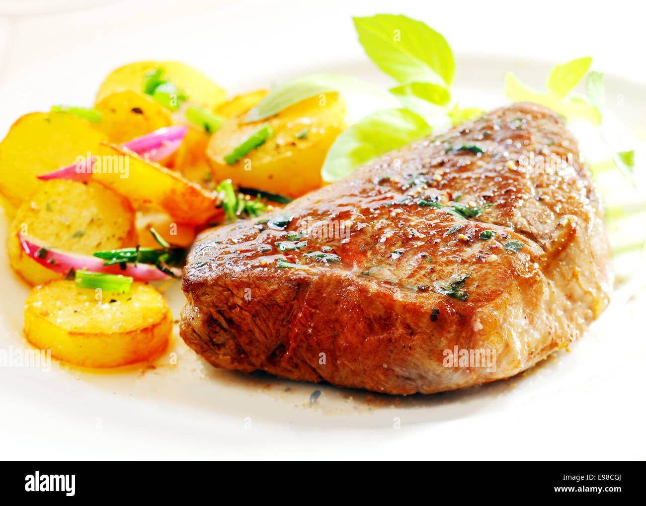 Large portion of thick juicy steak with crisp golden roast potatoes ...