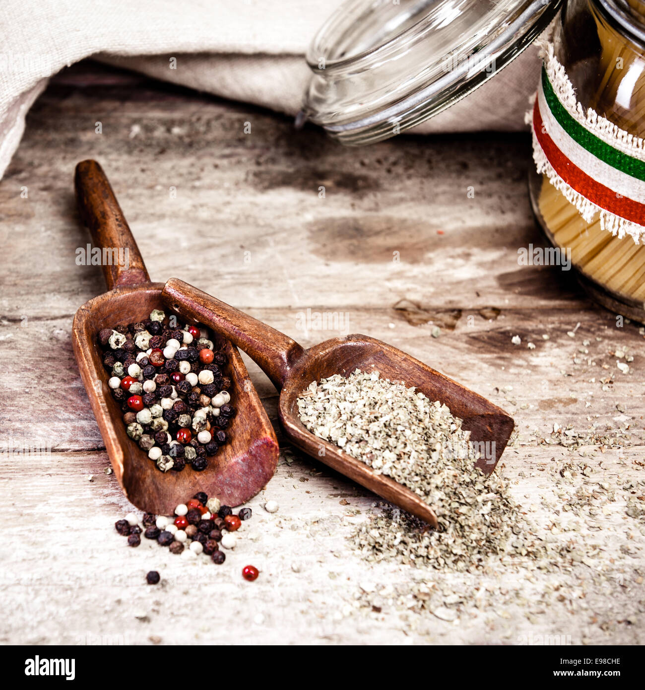 Fresh spices and condiments with whole peppercorns spilling from a ...