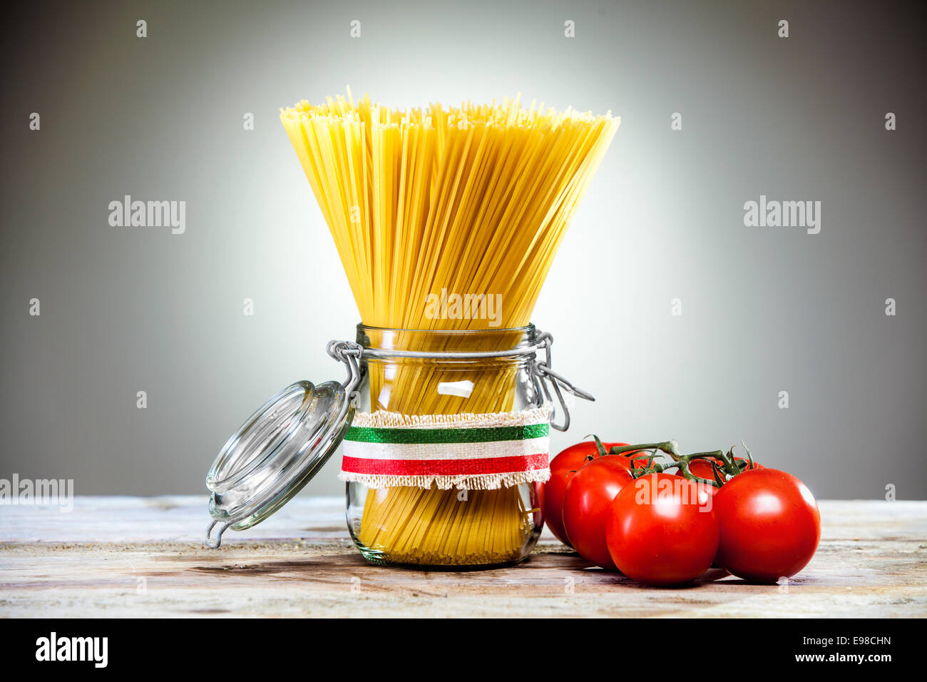 Uncooked dried Italian spaghetti tied with a ribbon in the colours of ...