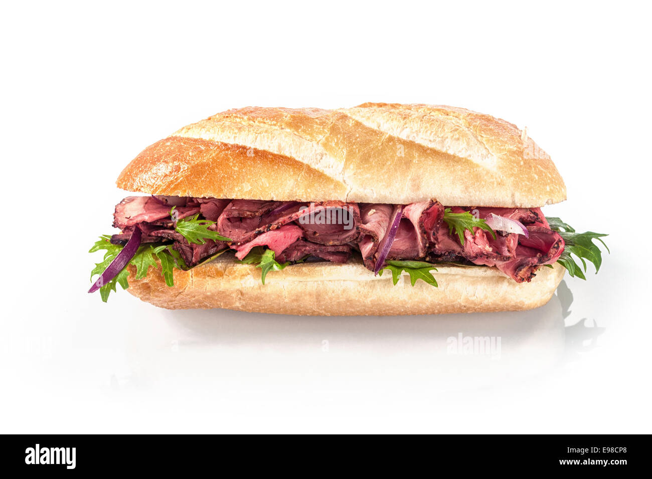 Slices of cold rare roast beef and fresh rocket on a crisp golden ...