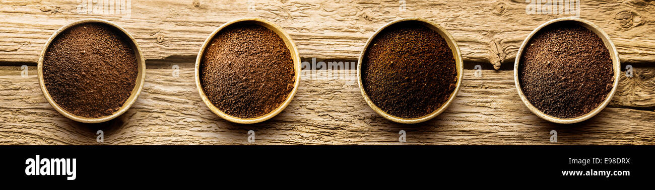 Four varieties of freshly ground coffee powder in individual dishes ...