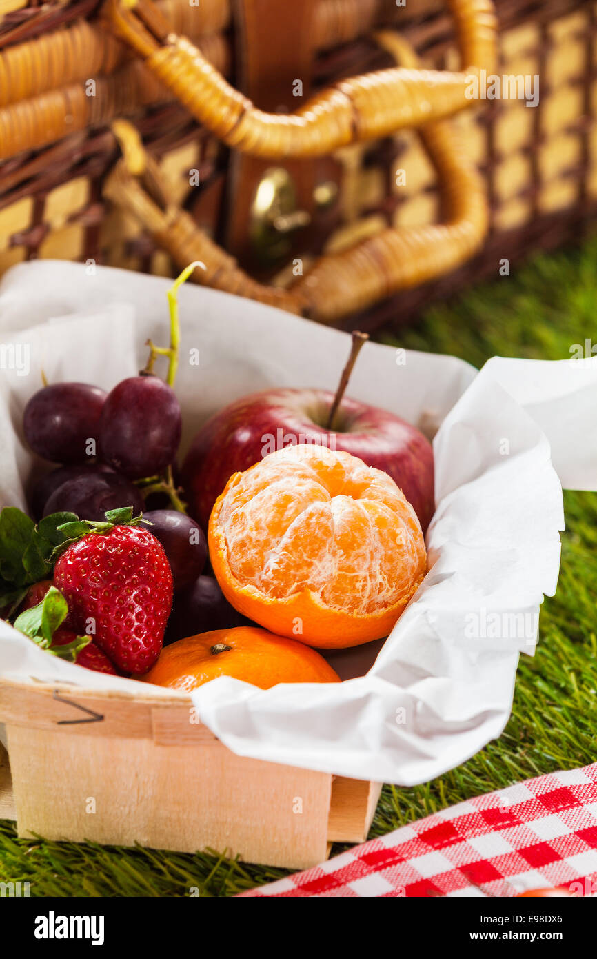Summer picnic hamper on green grass with a box filled with healthy ...
