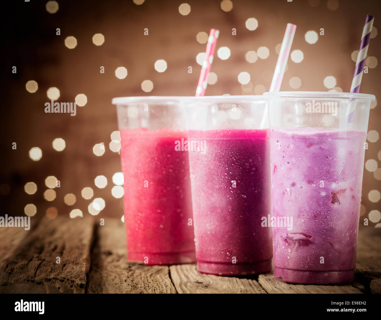 Three different colorful berry smoothies with twinkling party lights ...