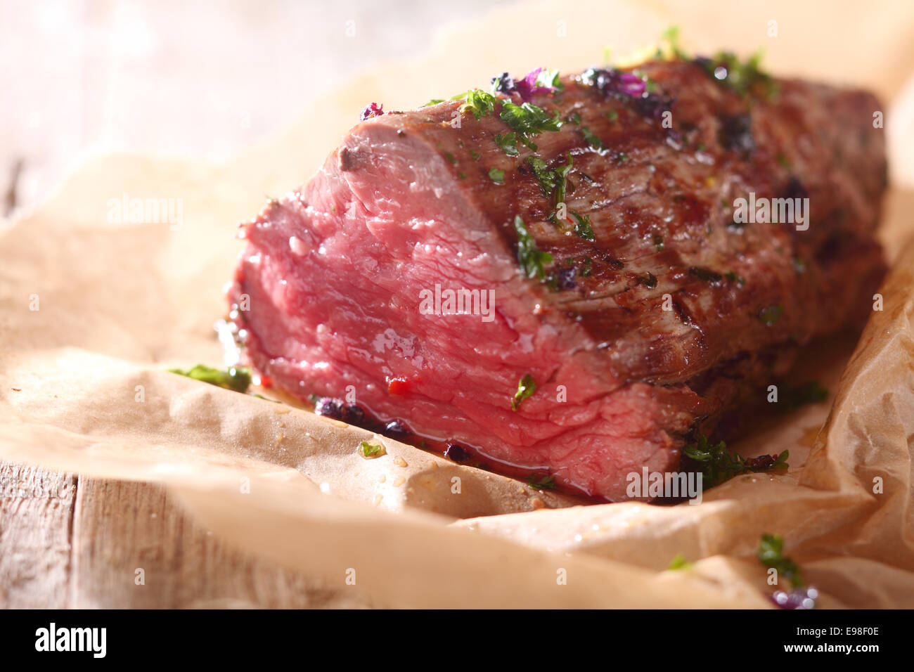 Side of rare roast beef fillet seasoned with fresh herbs cut through to ...