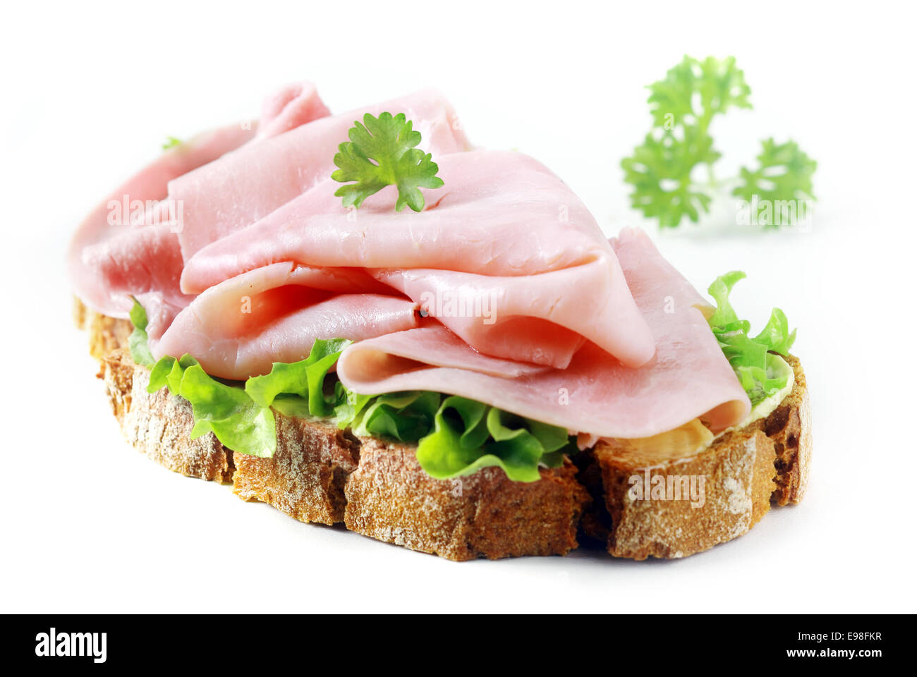Delicious thin gourmet cured ham slices on crusty rye bread with fresh ...